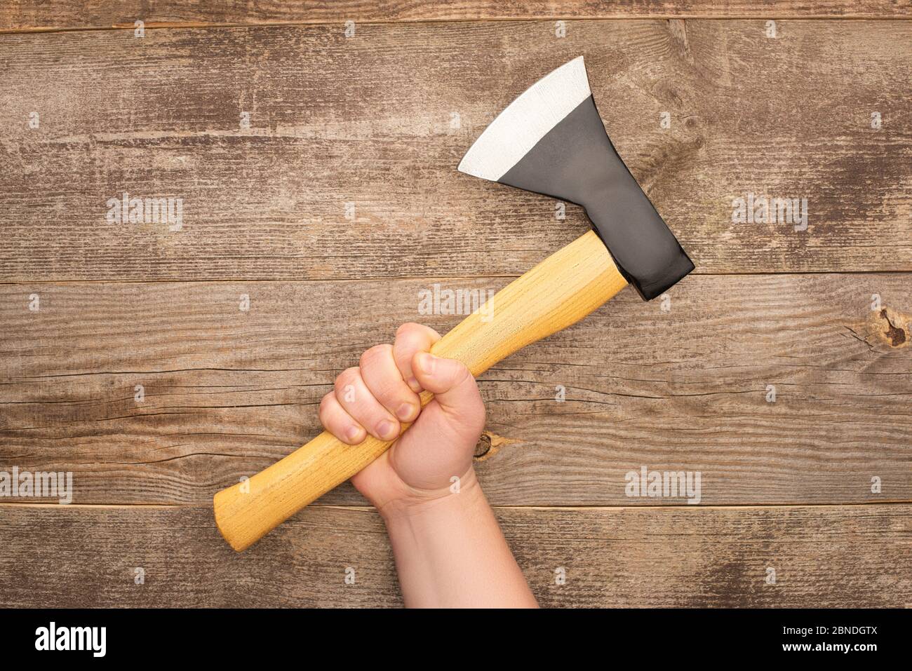partial view of man holding axe on wooden surface Stock Photo - Alamy