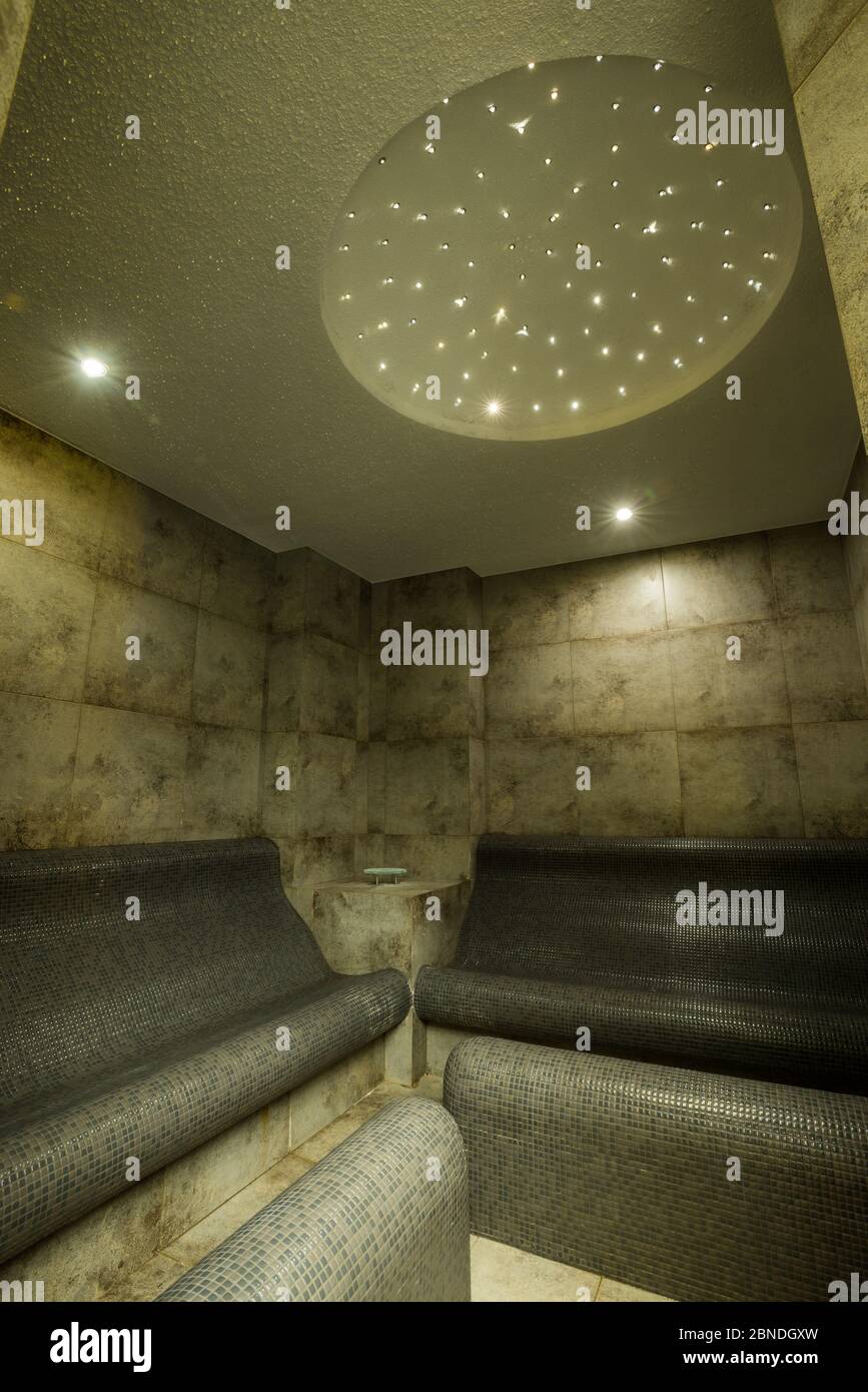 Vertical shot of a steam room design with a bench and marble wall tiles ...
