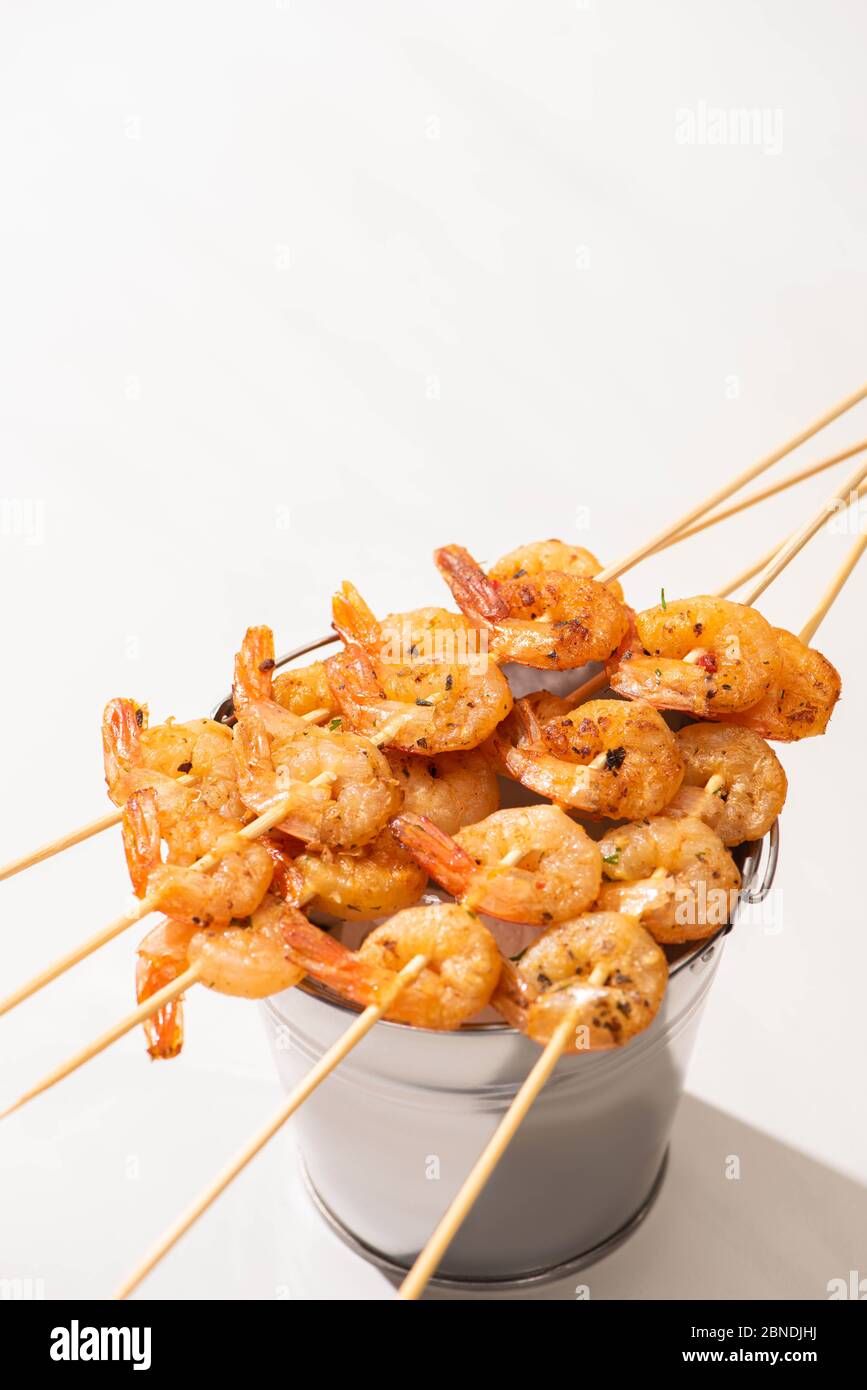 prawns on skewers on metal bucket on white background Stock Photo - Alamy
