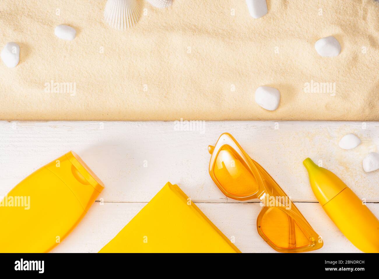 Top view of yellow sunglasses, book and sunscreens on white wooden ...