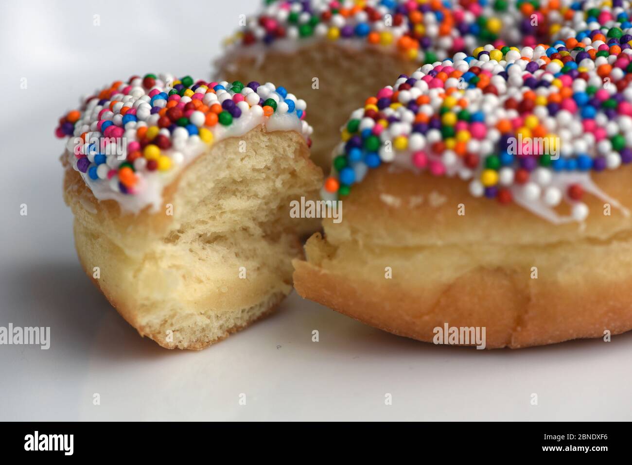 A triangular wedge section cut out of a doughnut with multi-coloured ...