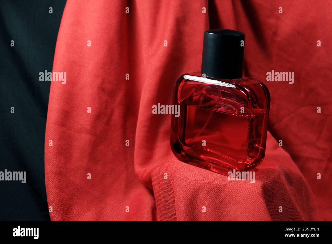 Red color men perfume bottle isolated on red silk background. Red ...