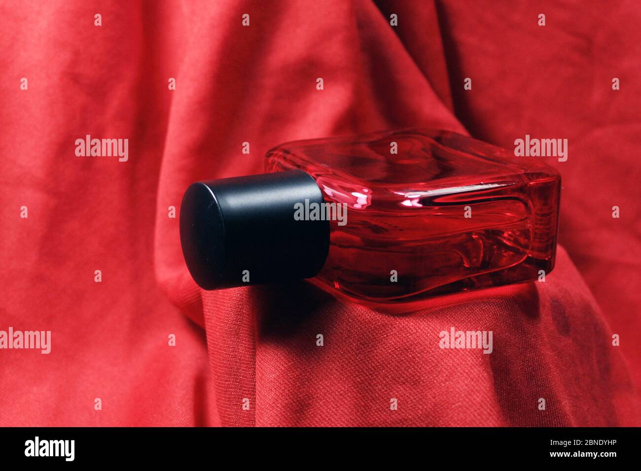 Red color men perfume bottle isolated on red silk background. Red ...