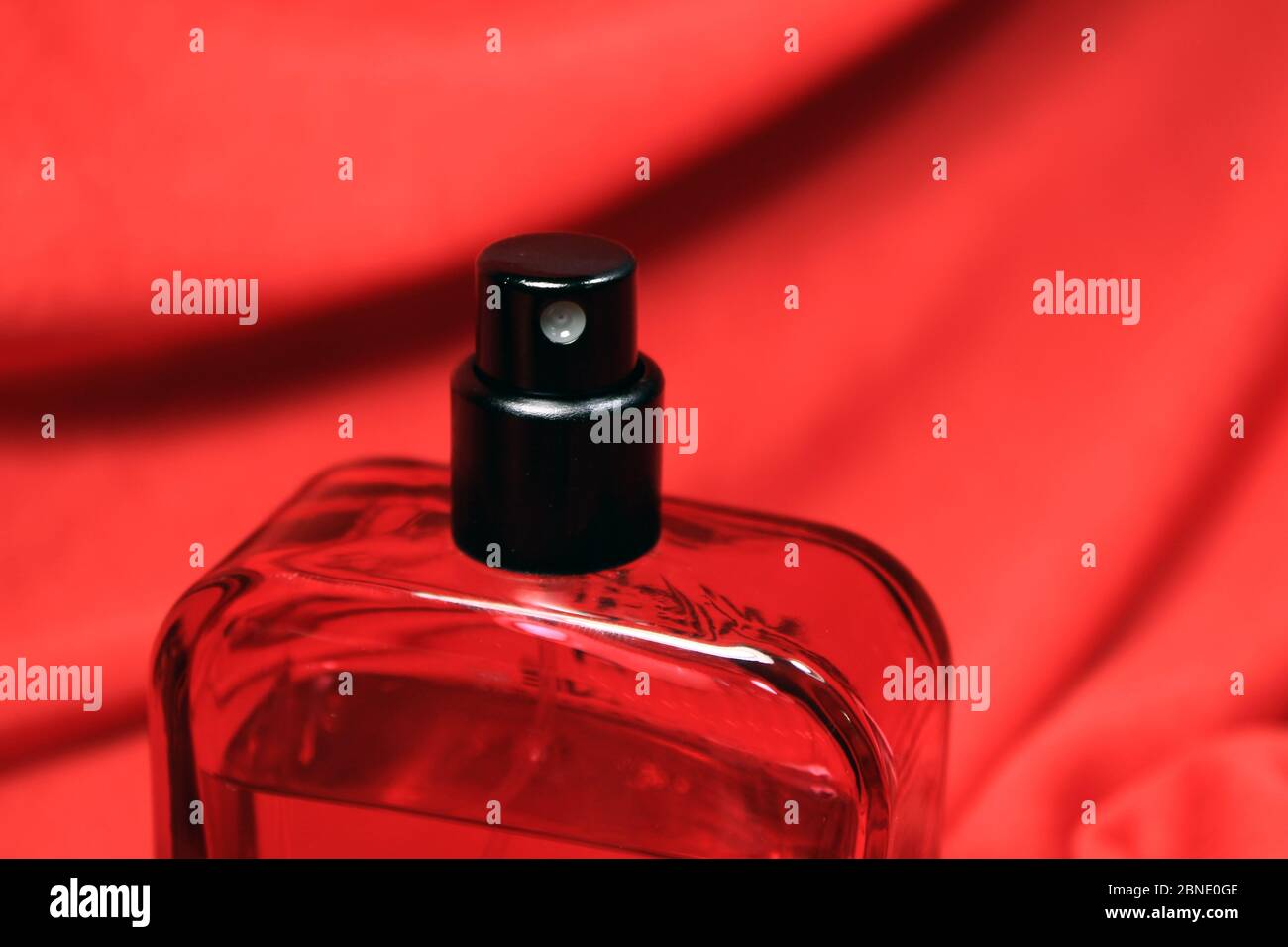 Red color men perfume bottle isolated on red silk background. Red ...