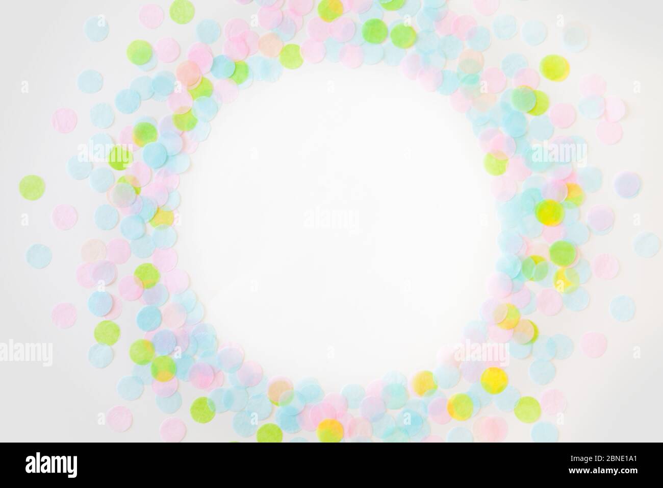 Round frame made of pastel colored confetti. White background. Festive ...