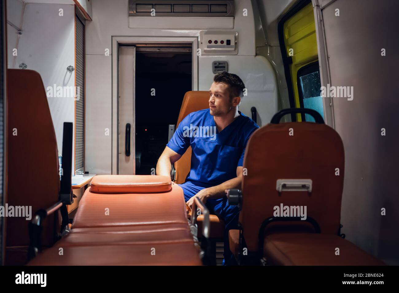 Corpsman sitting in an ambulance car and looking away Stock Photo - Alamy