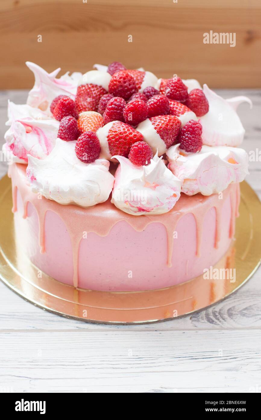 Pink cheese cake with melted chocolate, meringues, fresh raspberries ...