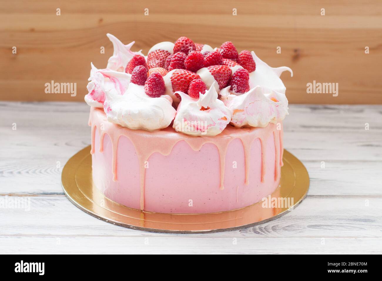 Pink cheese cake with melted chocolate, meringues, fresh raspberries ...