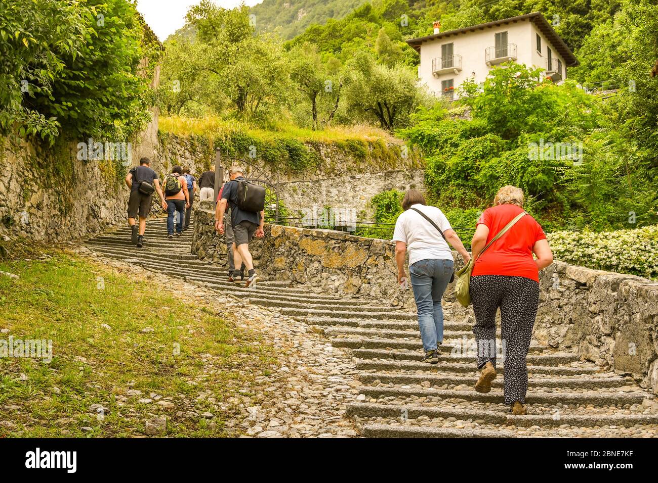 LAKE COMO, ITALY - JUNE 2019: People walking up steps on the route of a ...