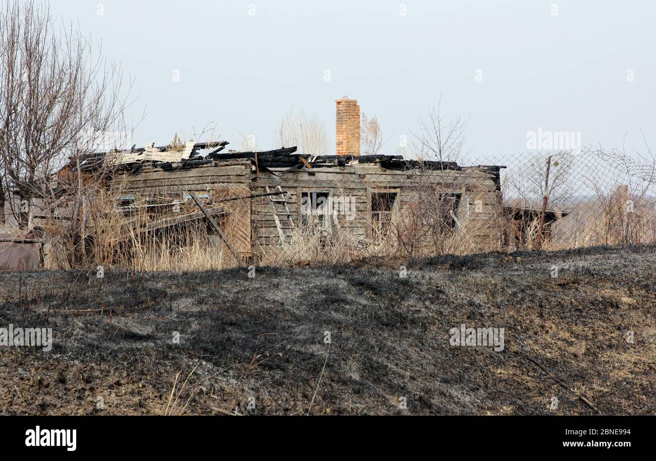 Burnt wooden country house with a brick pipe Stock Photo - Alamy