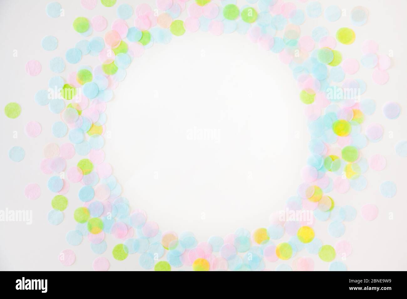 Round frame made of pastel colored confetti. White background. Festive ...