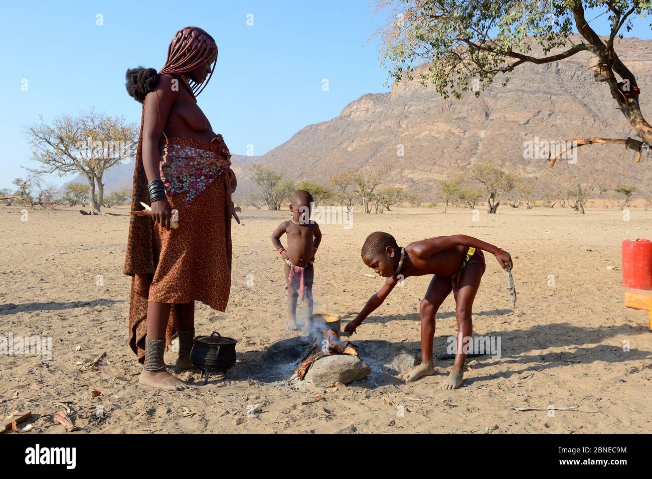 Himba girl starting fire with her mother for the cooking, Marienfluss ...