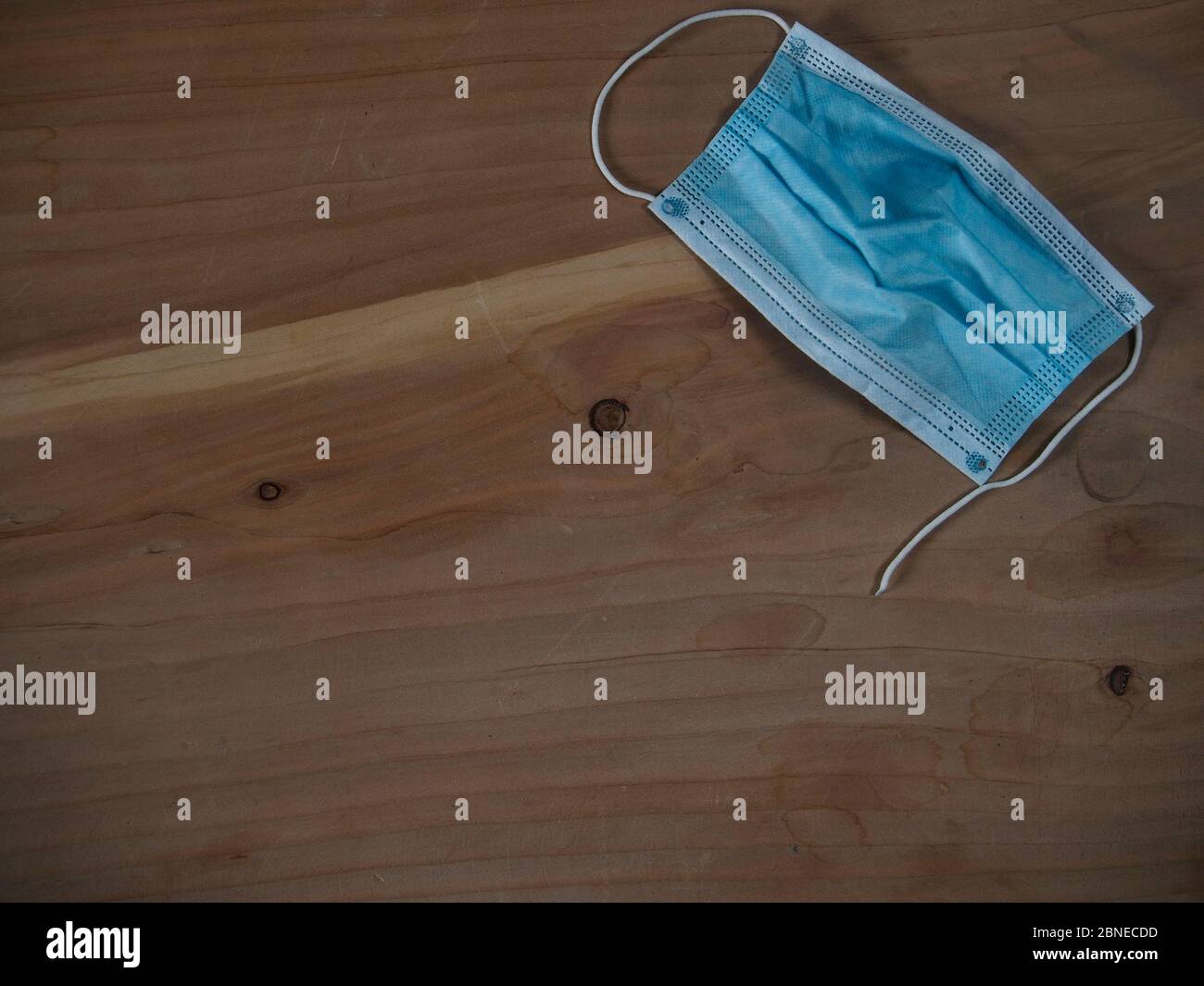 used and broken 3-ply blue surgical mask to cover the mouth and nose ...