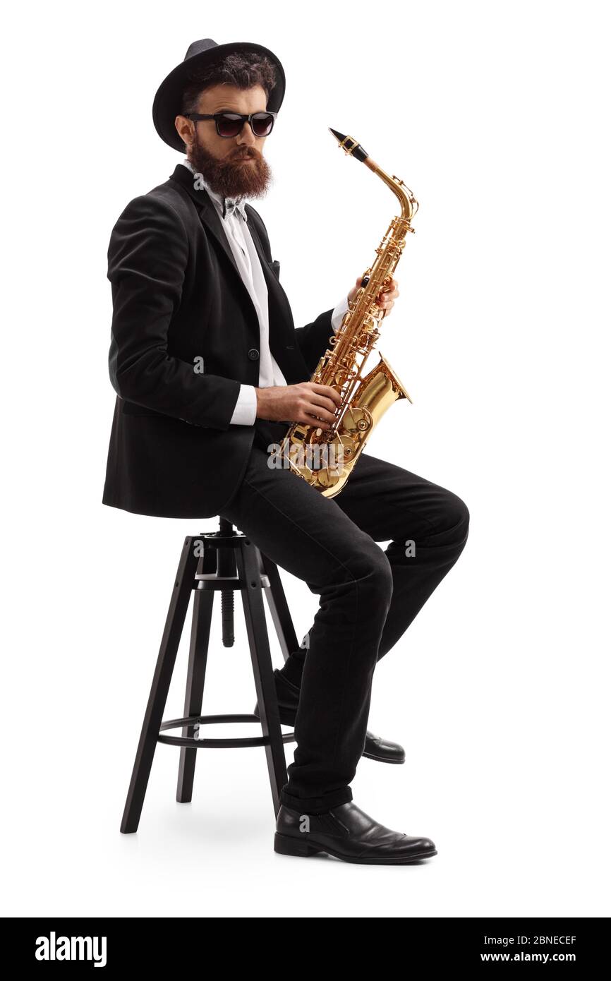 Bearded musician holding a saxophone and sitting on a chair isolated on ...
