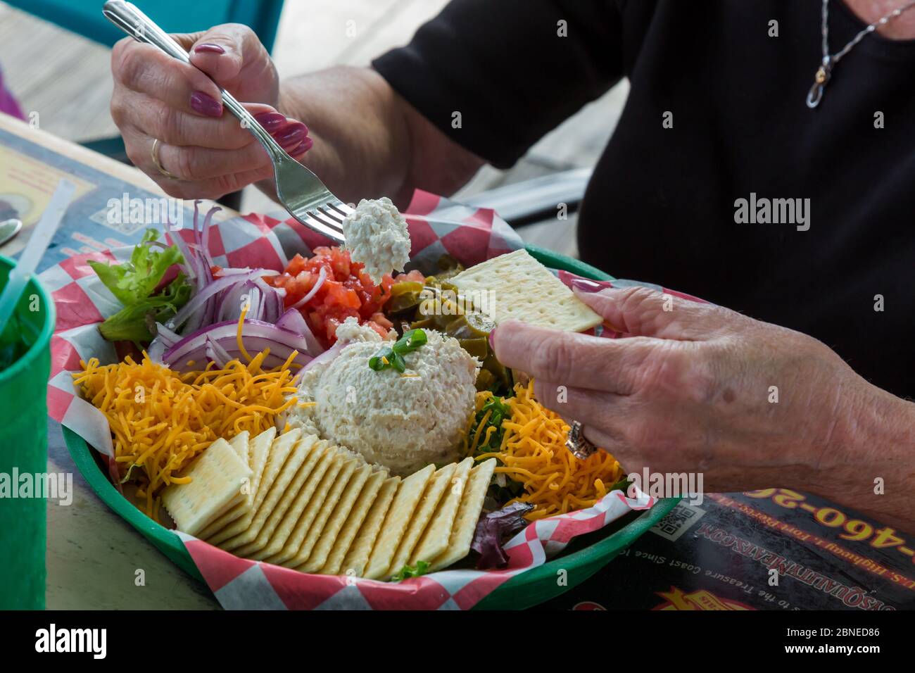 A hungry woman eats from the colorful Simmerlin Fish Smak Sampler ...