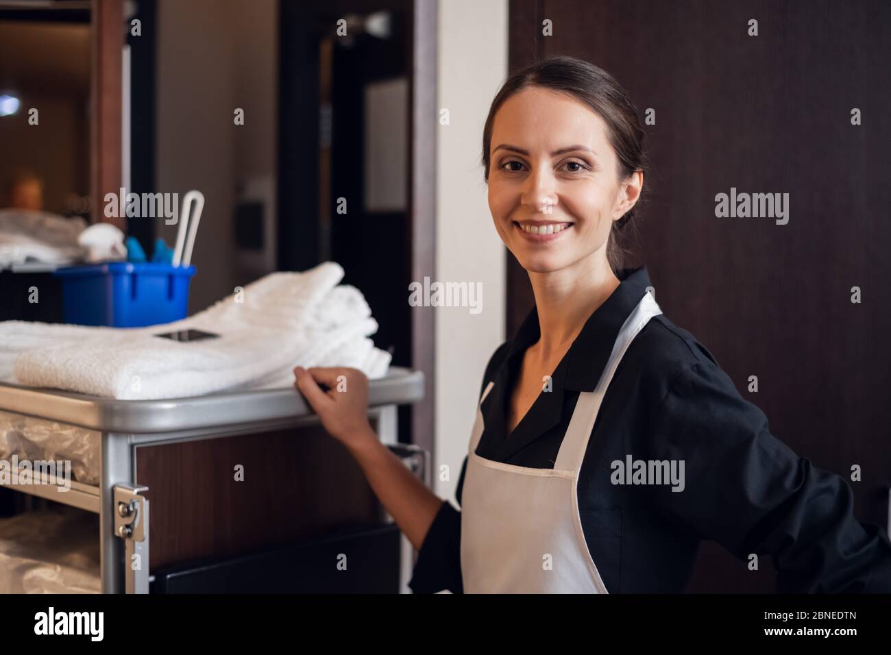 A portrait of a smiling housekeeping lady in a uniform Stock Photo - Alamy