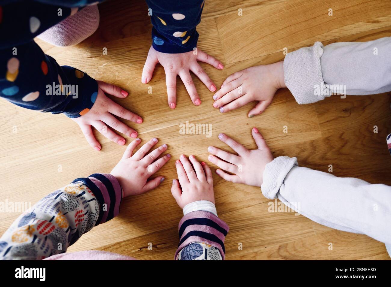 Beautiful picture of kids showing up their hands on a wooden floor ...