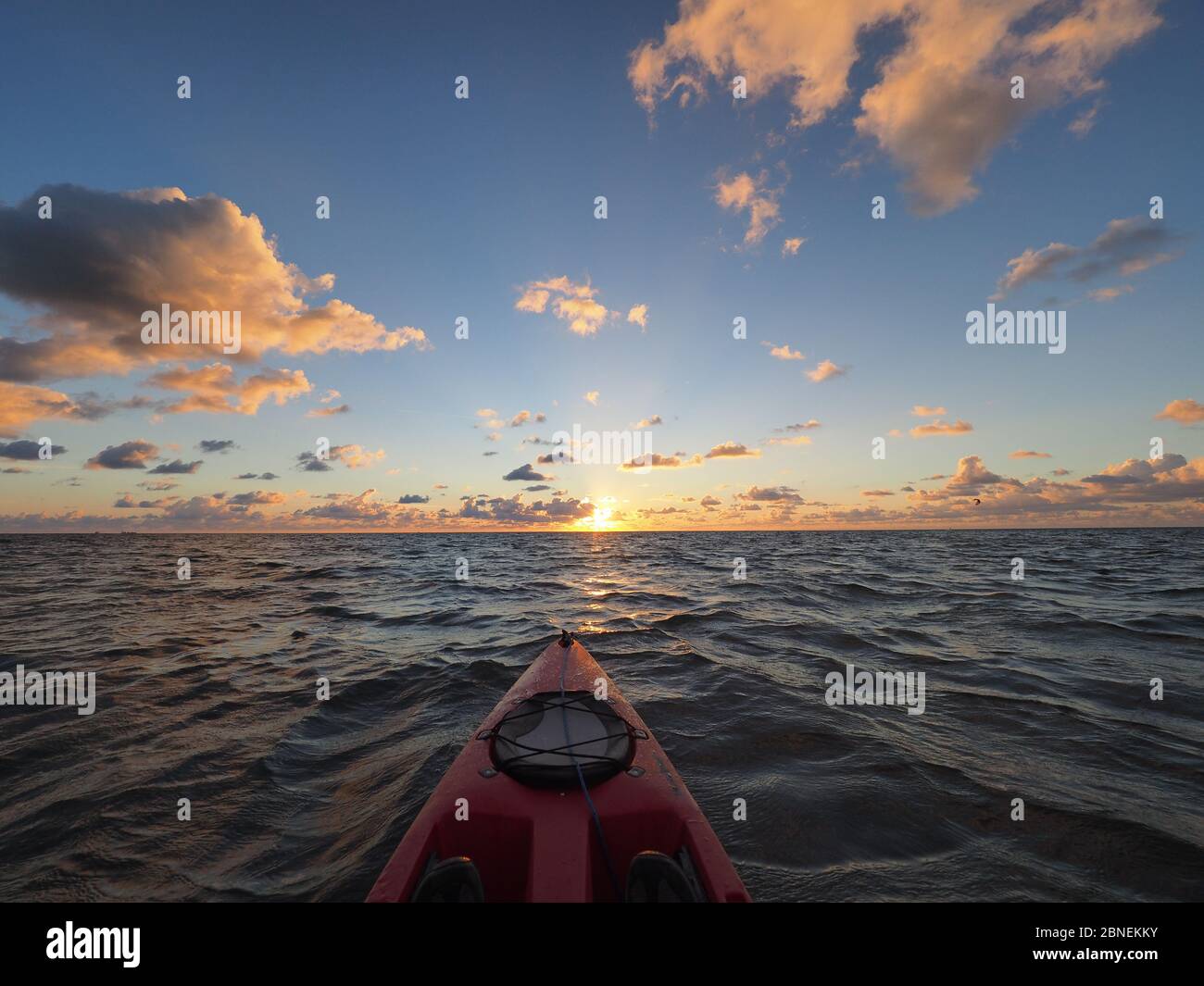 Red kayak pointing toward horizon at sunrise on windy morning in Bear ...