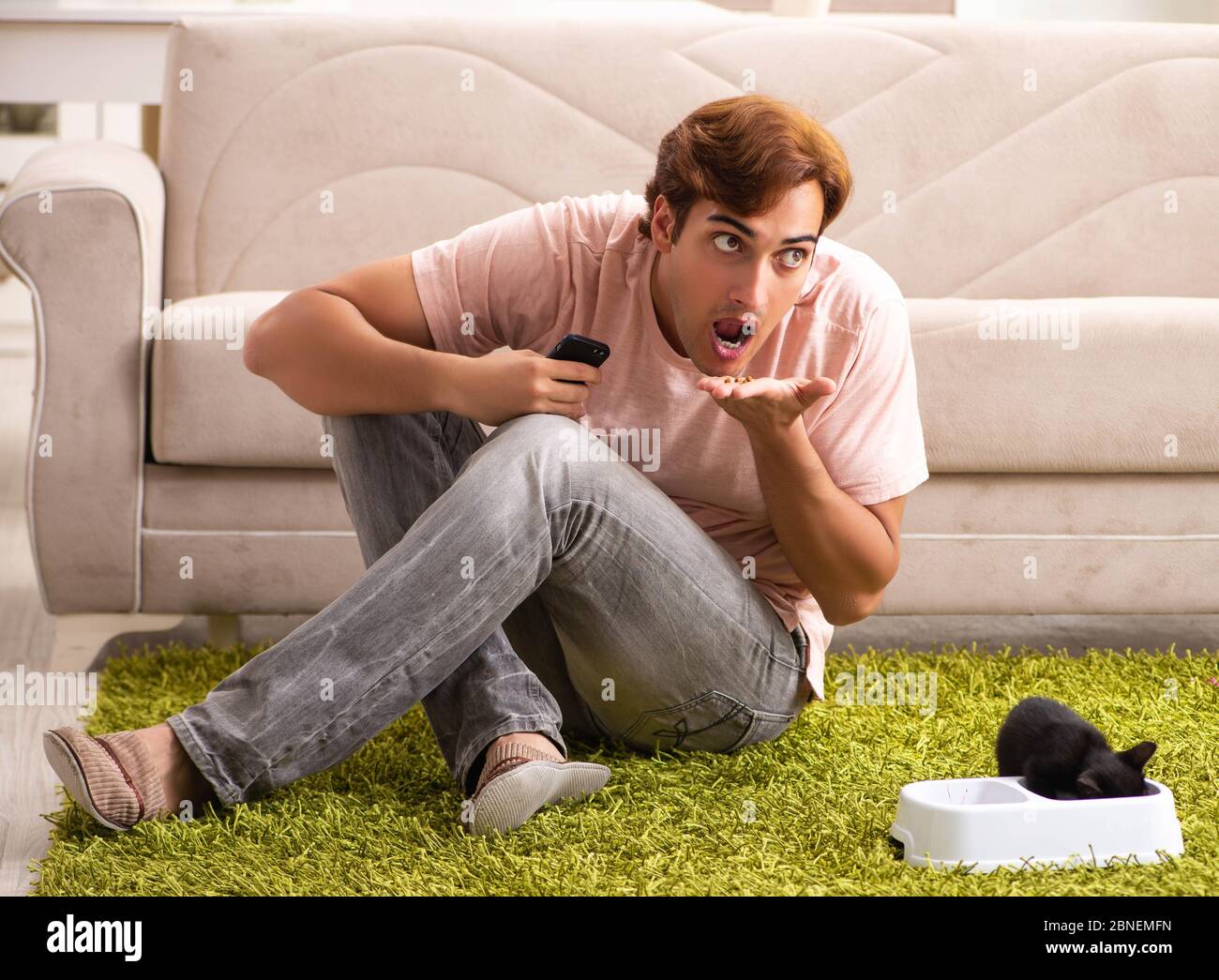 Handsome man playing black cat hi-res stock photography and images - Alamy