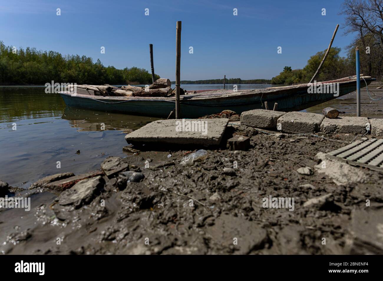 Boat anchored at the muddy river bank Stock Photo - Alamy