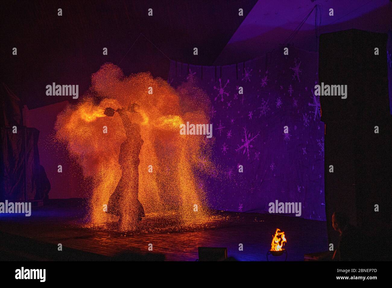 Amazing view of fire performer standing on a stage Stock Photo - Alamy