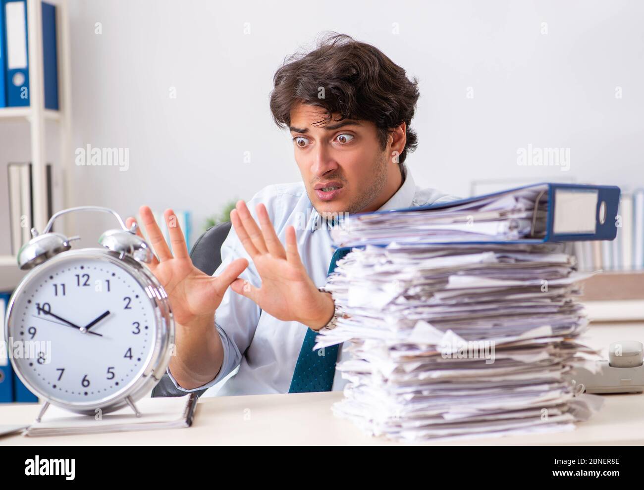 The overloaded busy employee with too much work and paperwork Stock ...