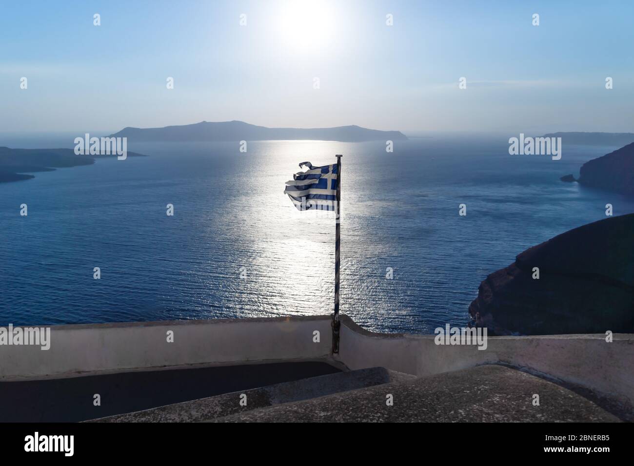 Greek flattering torn flag on backlight of the shining ocean of last ...