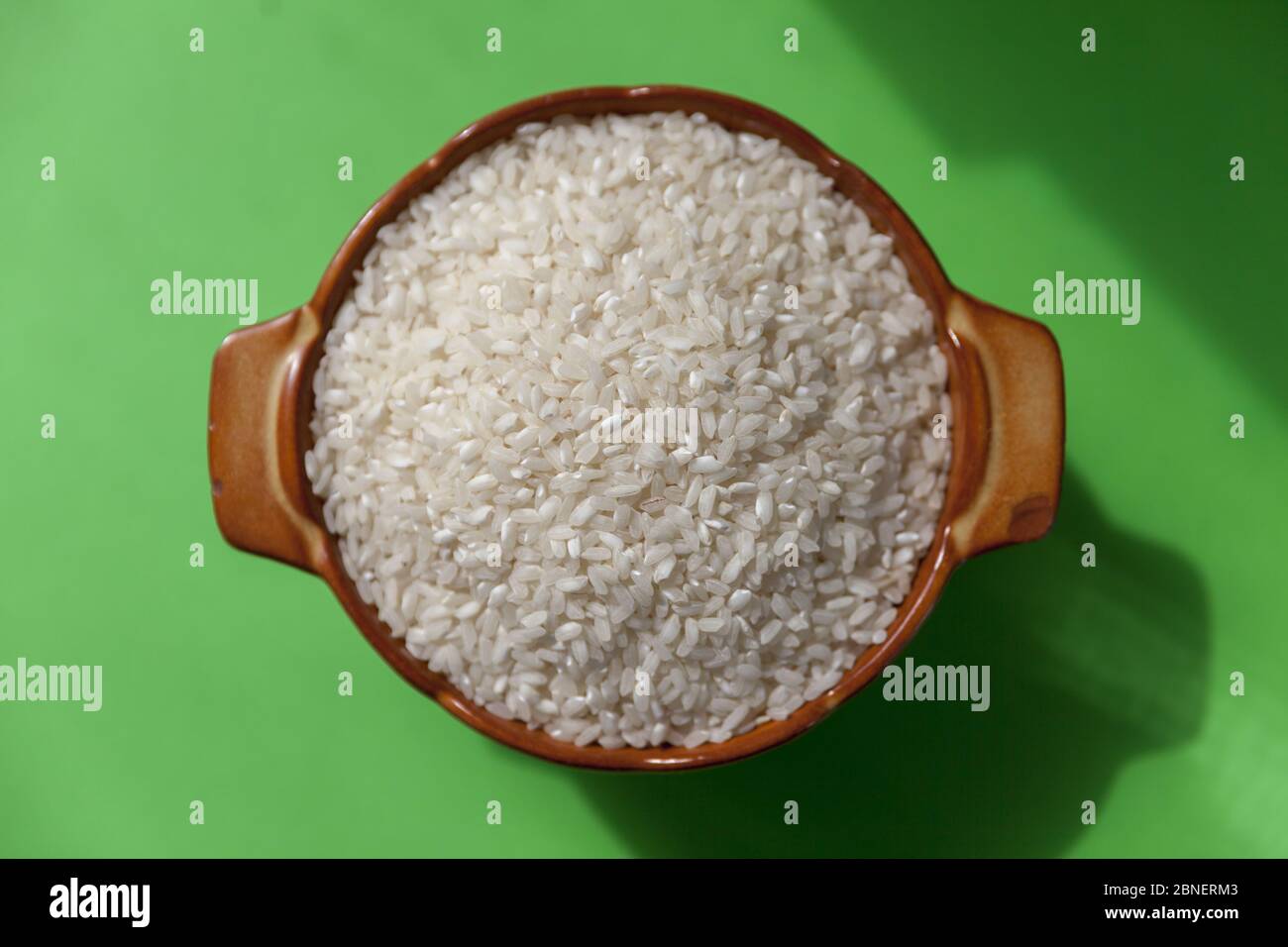 white rice in ceramic bowl, green background Stock Photo - Alamy