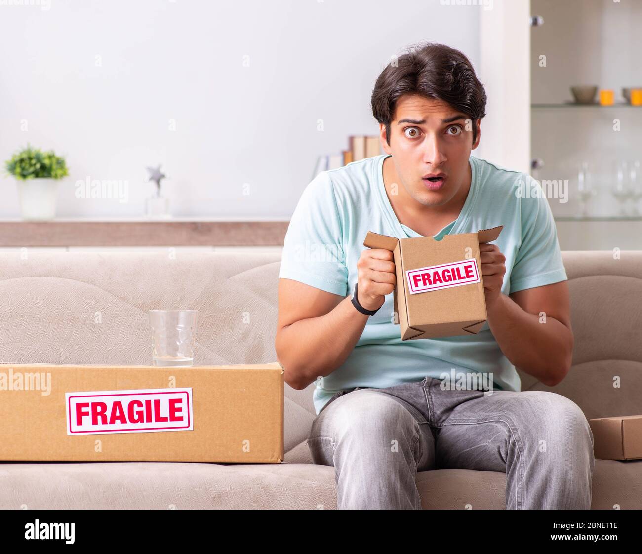 The man opening fragile parcel ordered from internet Stock Photo - Alamy
