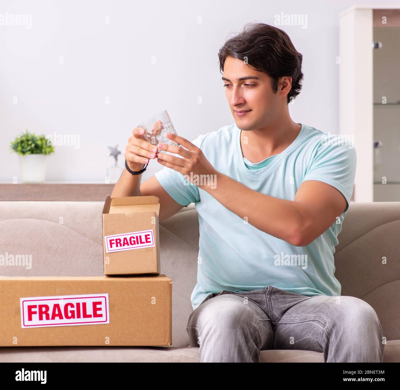 The man opening fragile parcel ordered from internet Stock Photo - Alamy
