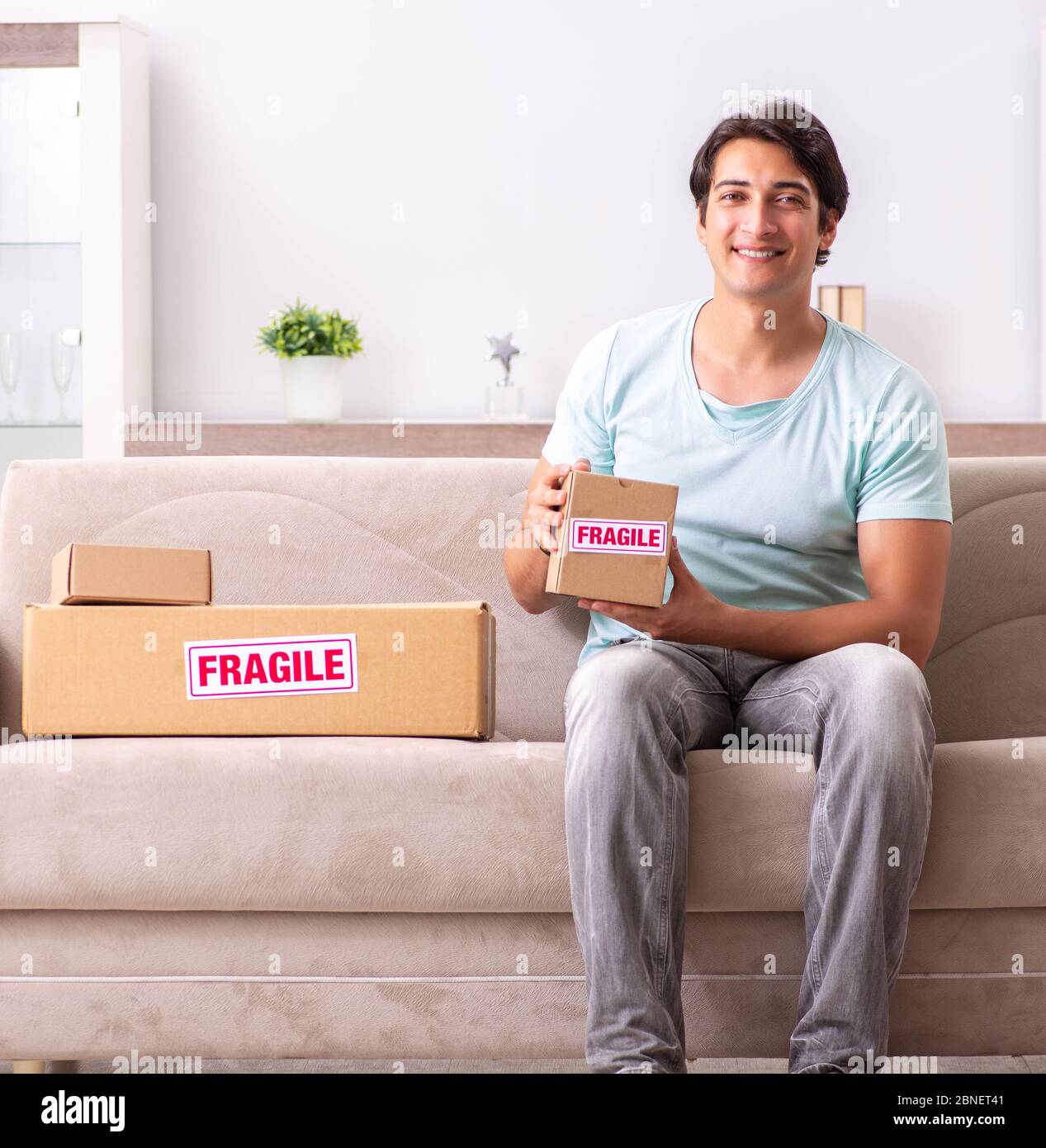 The man opening fragile parcel ordered from internet Stock Photo - Alamy