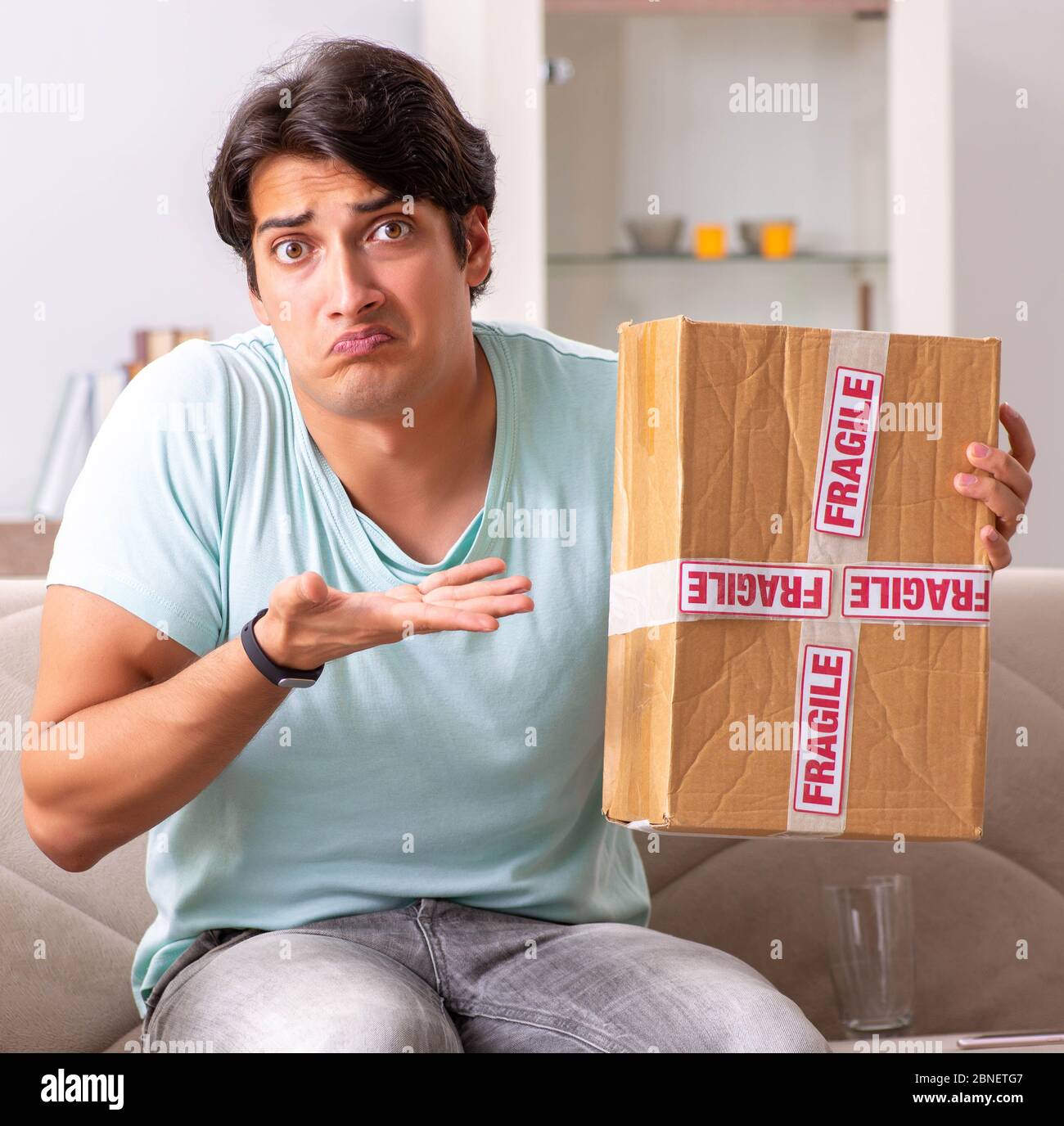 The man opening fragile parcel ordered from internet Stock Photo - Alamy