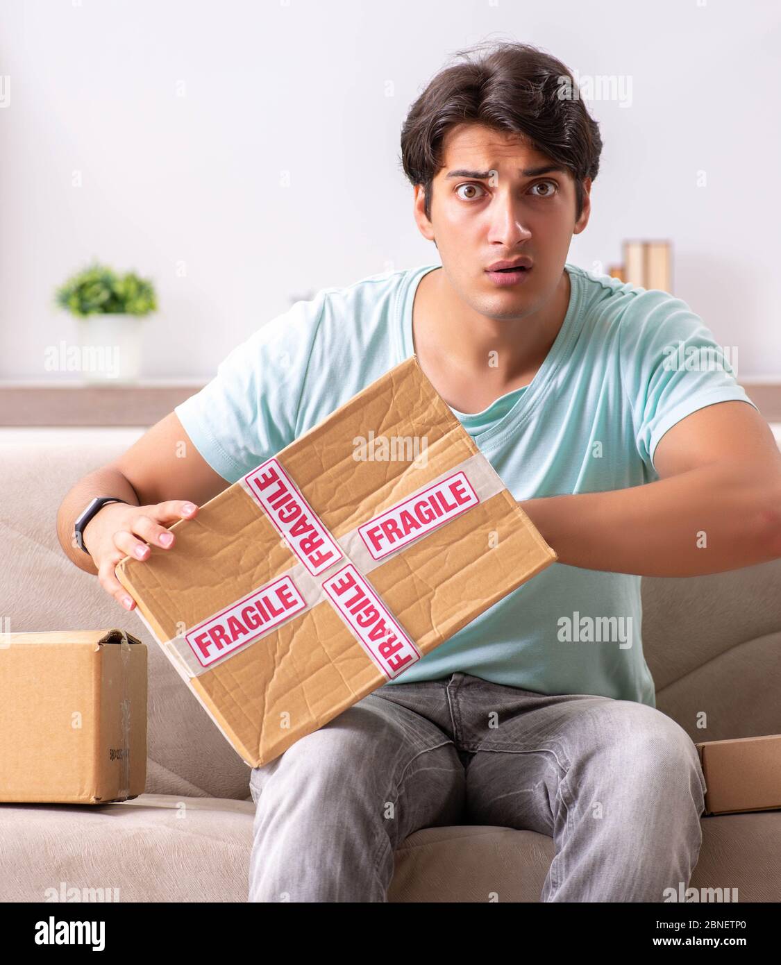 The man opening fragile parcel ordered from internet Stock Photo - Alamy