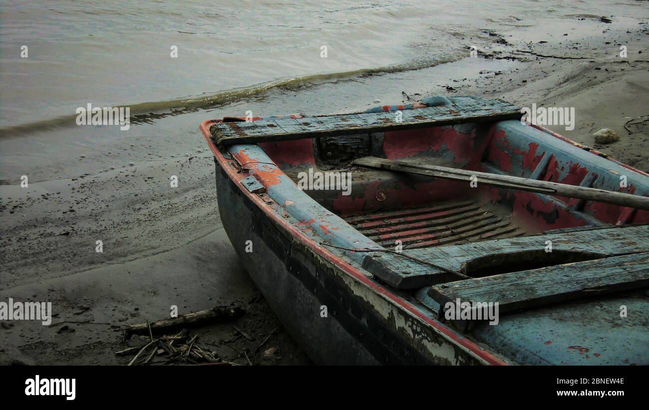 Small wooden boat destroyed and worn by time and weather abandoned on ...