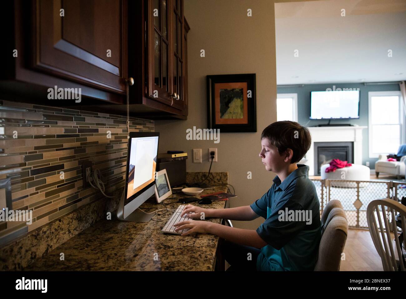 Wide View of Tween Boy Typing on Keyboard at Computer Desk Stock Photo ...