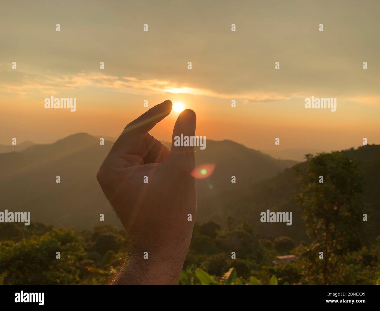 catching the sun with one hand Stock Photo - Alamy