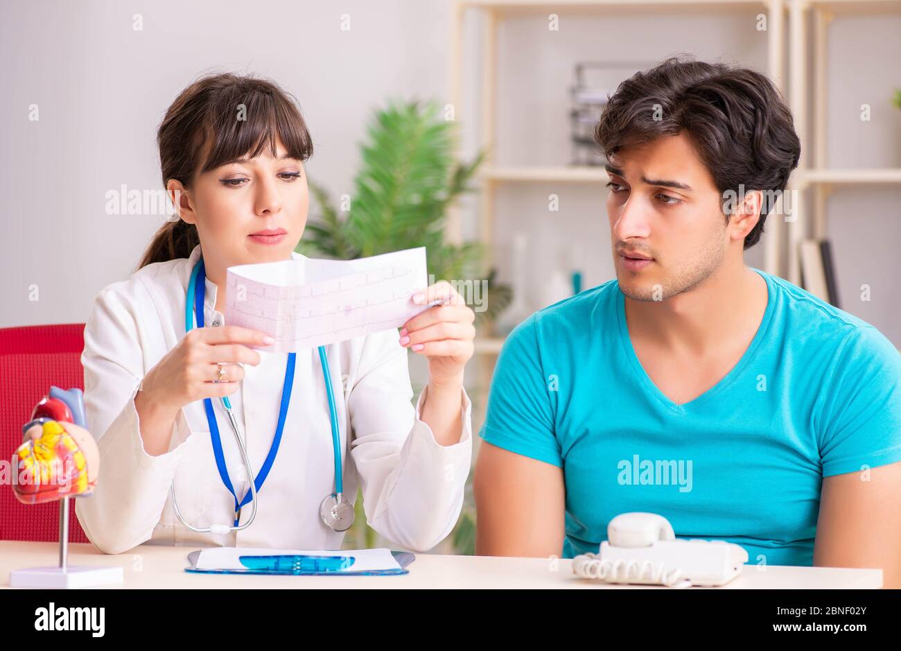 The young man visiting female doctor cardiologist Stock Photo - Alamy