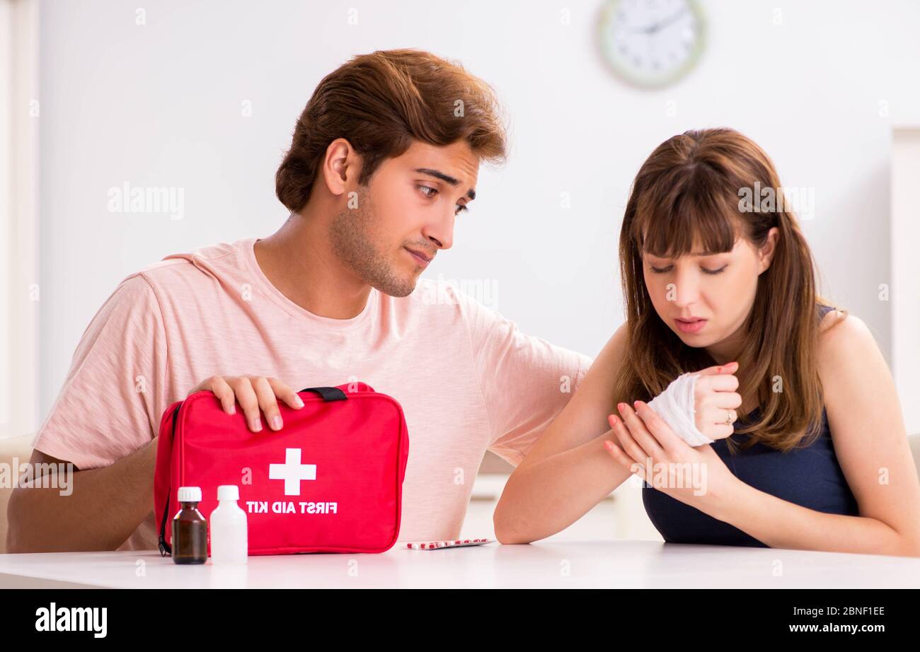 The young family getting treatment with first aid kit Stock Photo - Alamy