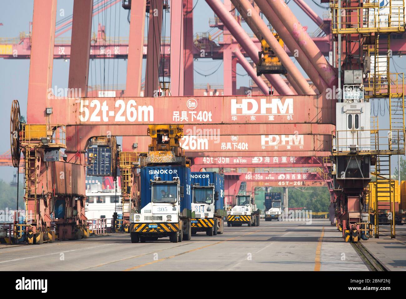 Trucks work to move containers for better loading and unloading at a ...