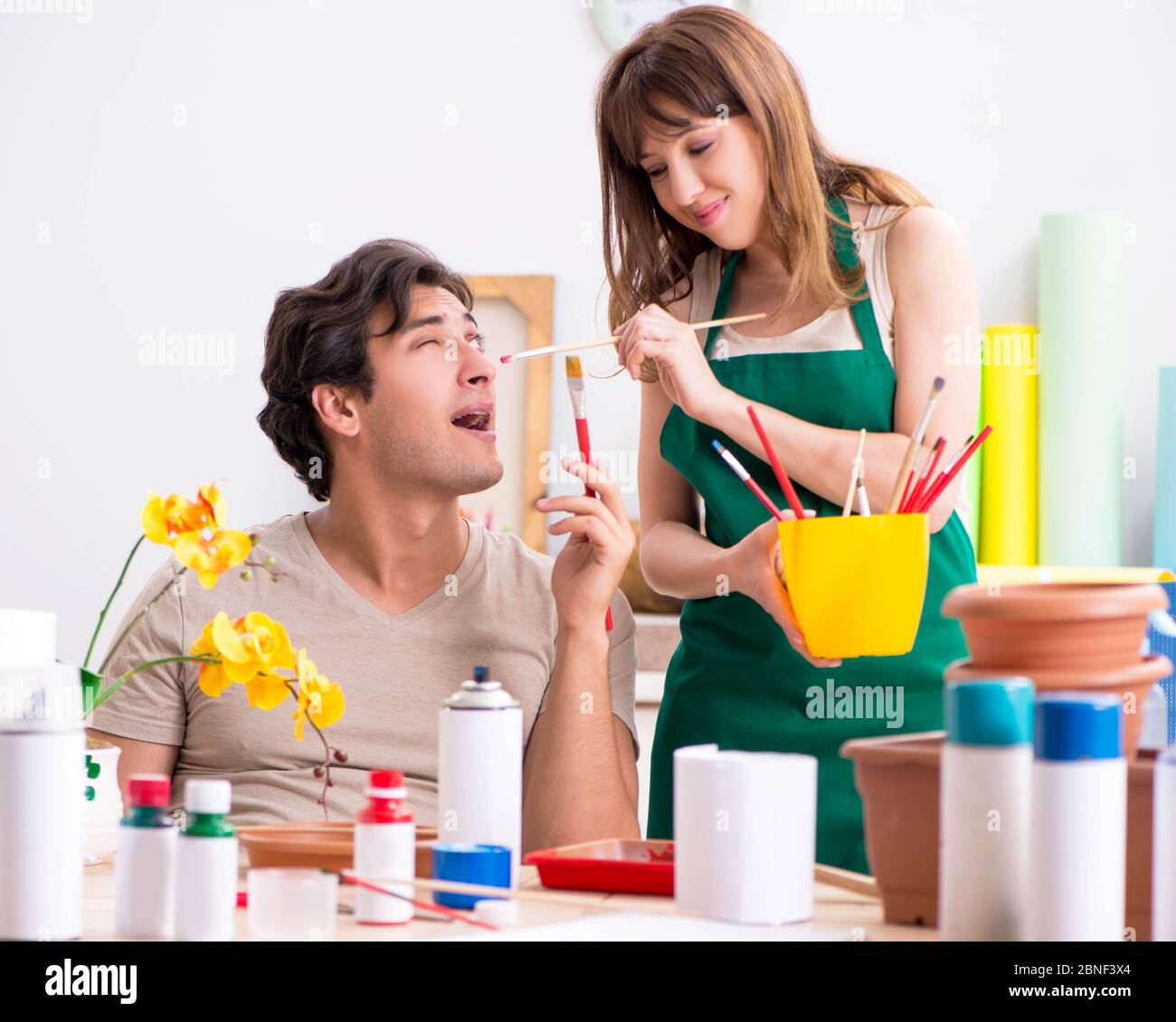 The couple decorating pots in workshop during class Stock Photo - Alamy
