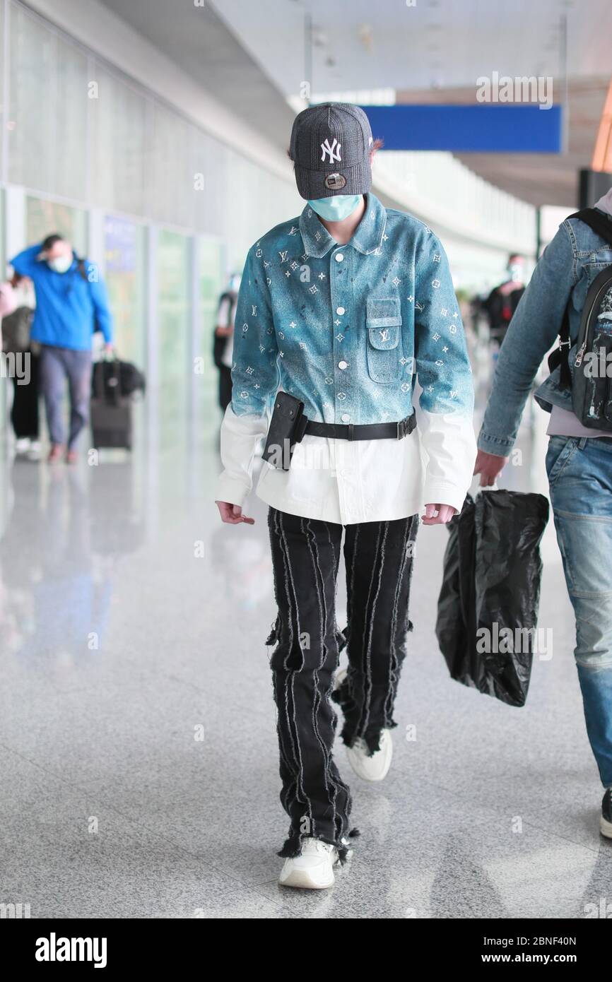Chinese singer Ling Chao arrives at a Beijing airport before departure ...