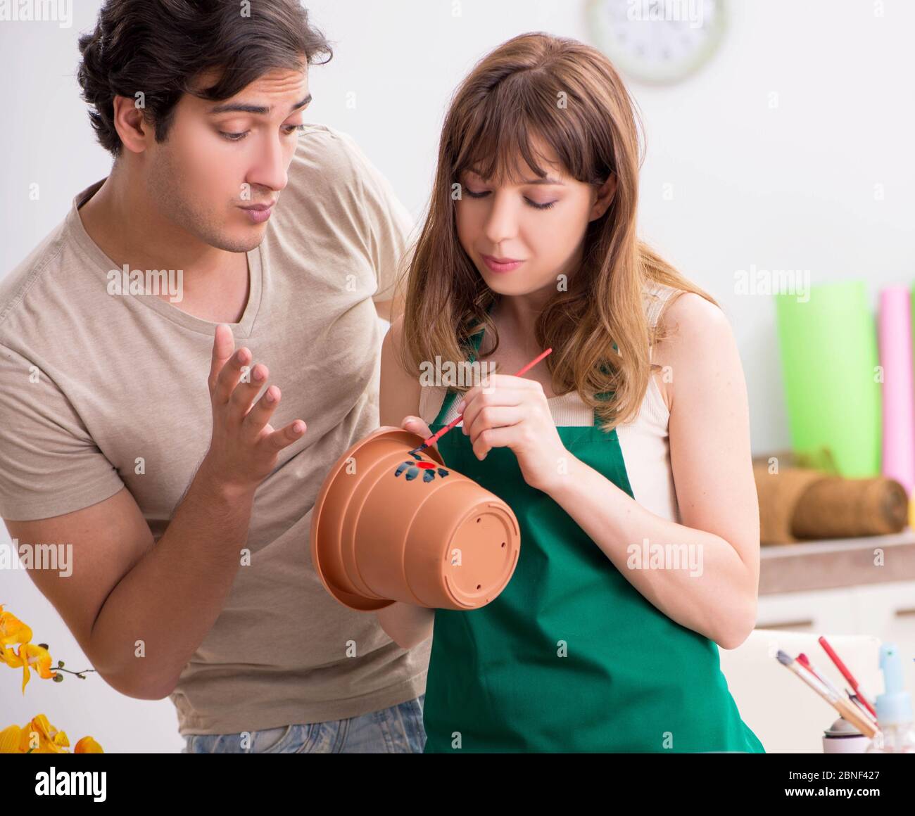 The couple decorating pots in workshop during class Stock Photo - Alamy