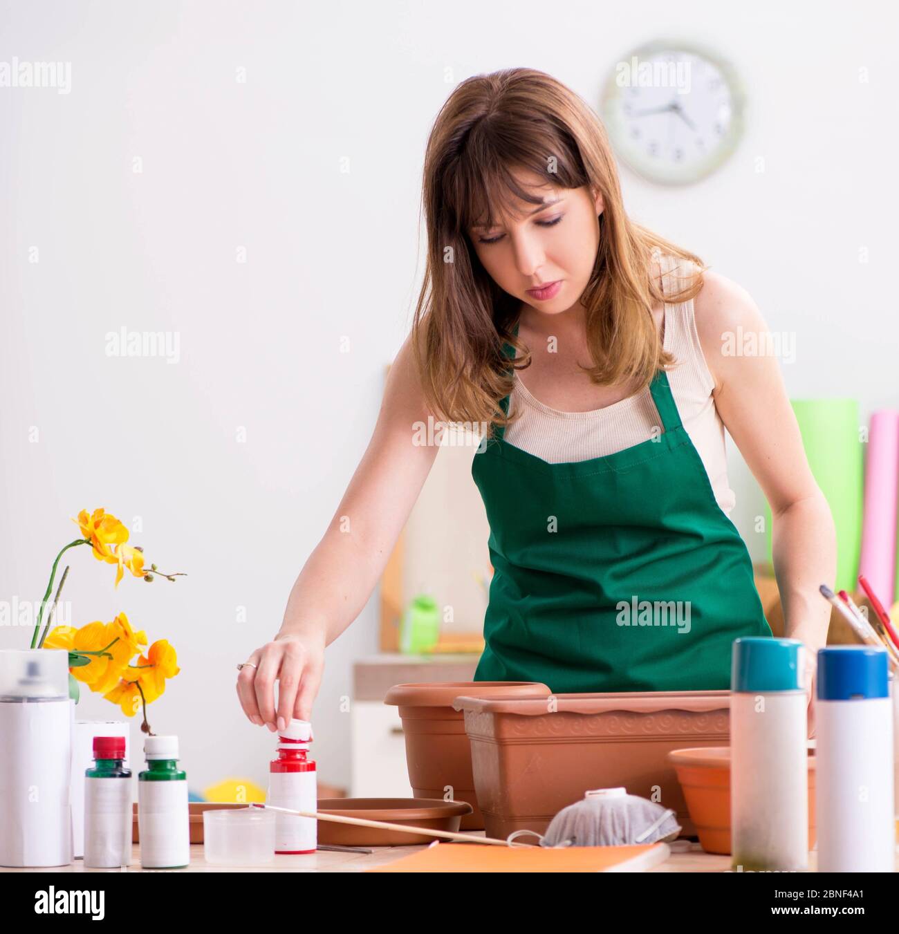 The young woman decorating pottery in workshop Stock Photo - Alamy