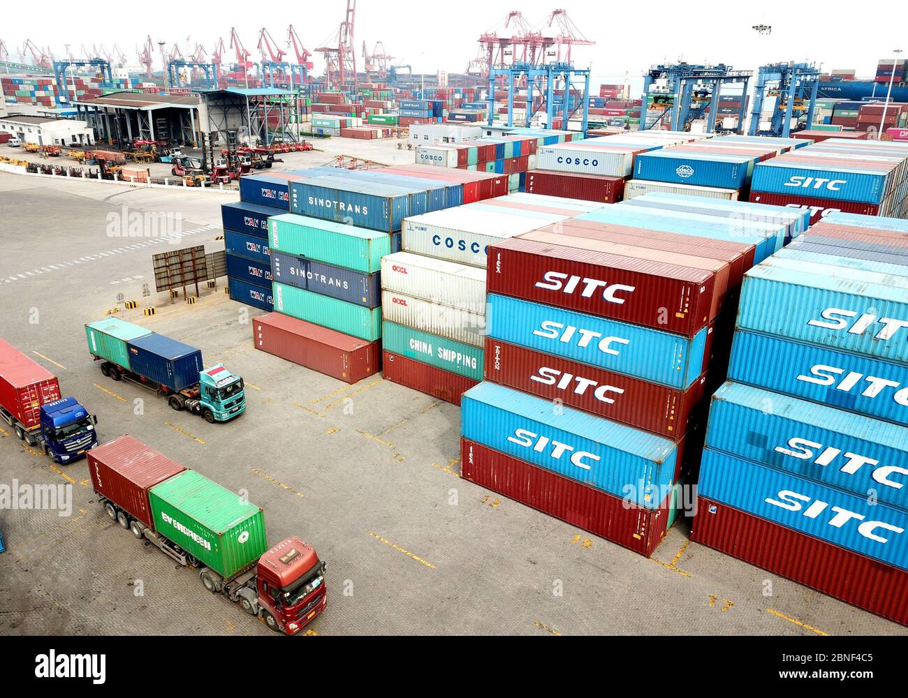 Trucks are busy at loading containers on vessels which export goods ...