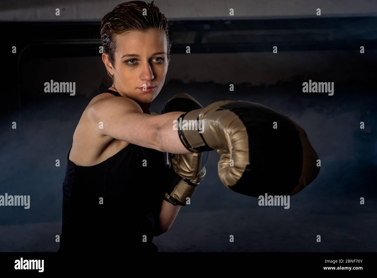 Closeup picture of beautiful female boxer practicing her punches with ...