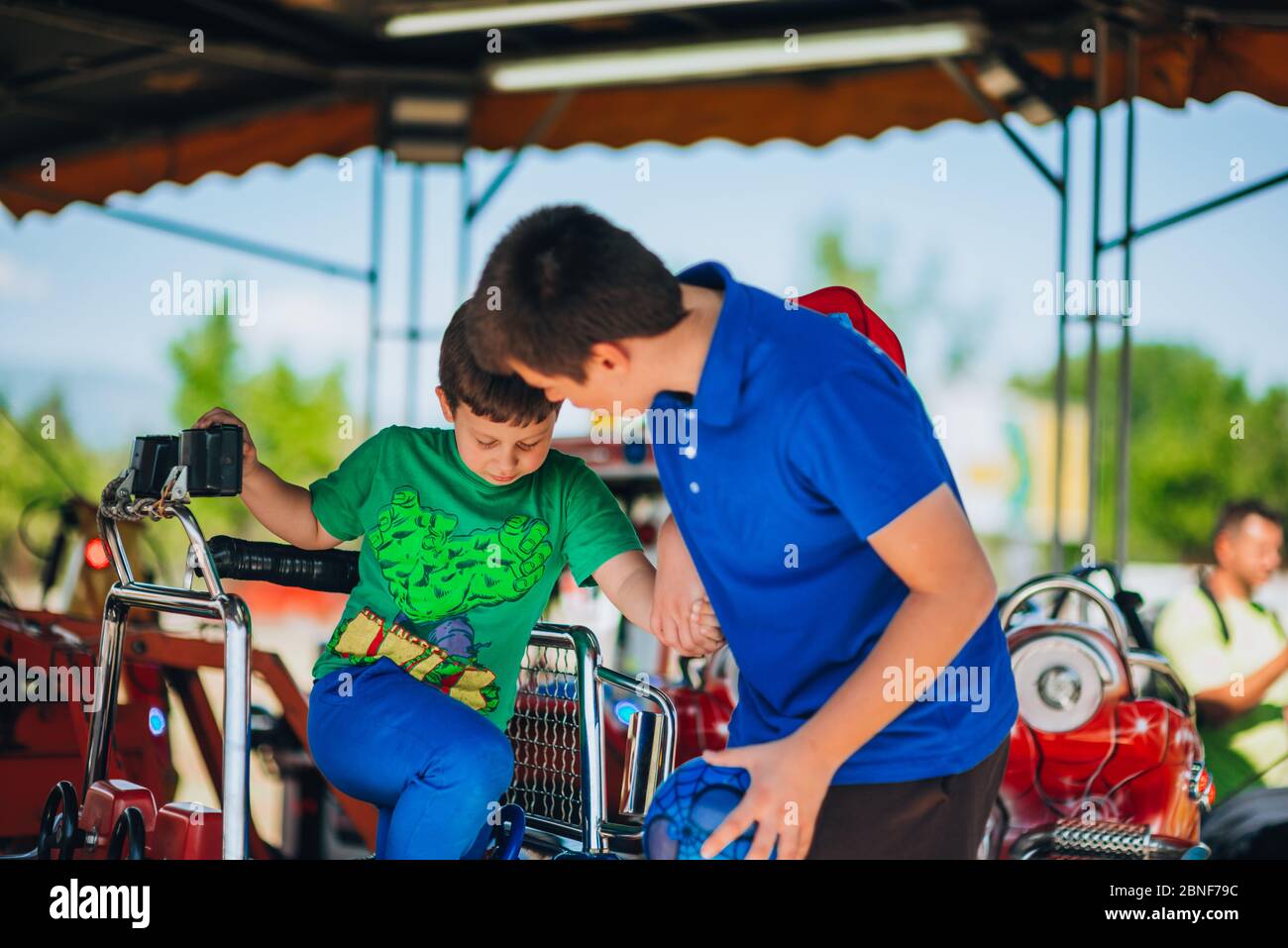 Little cheerful kid enjoying the rides at the local funfair park Stock ...