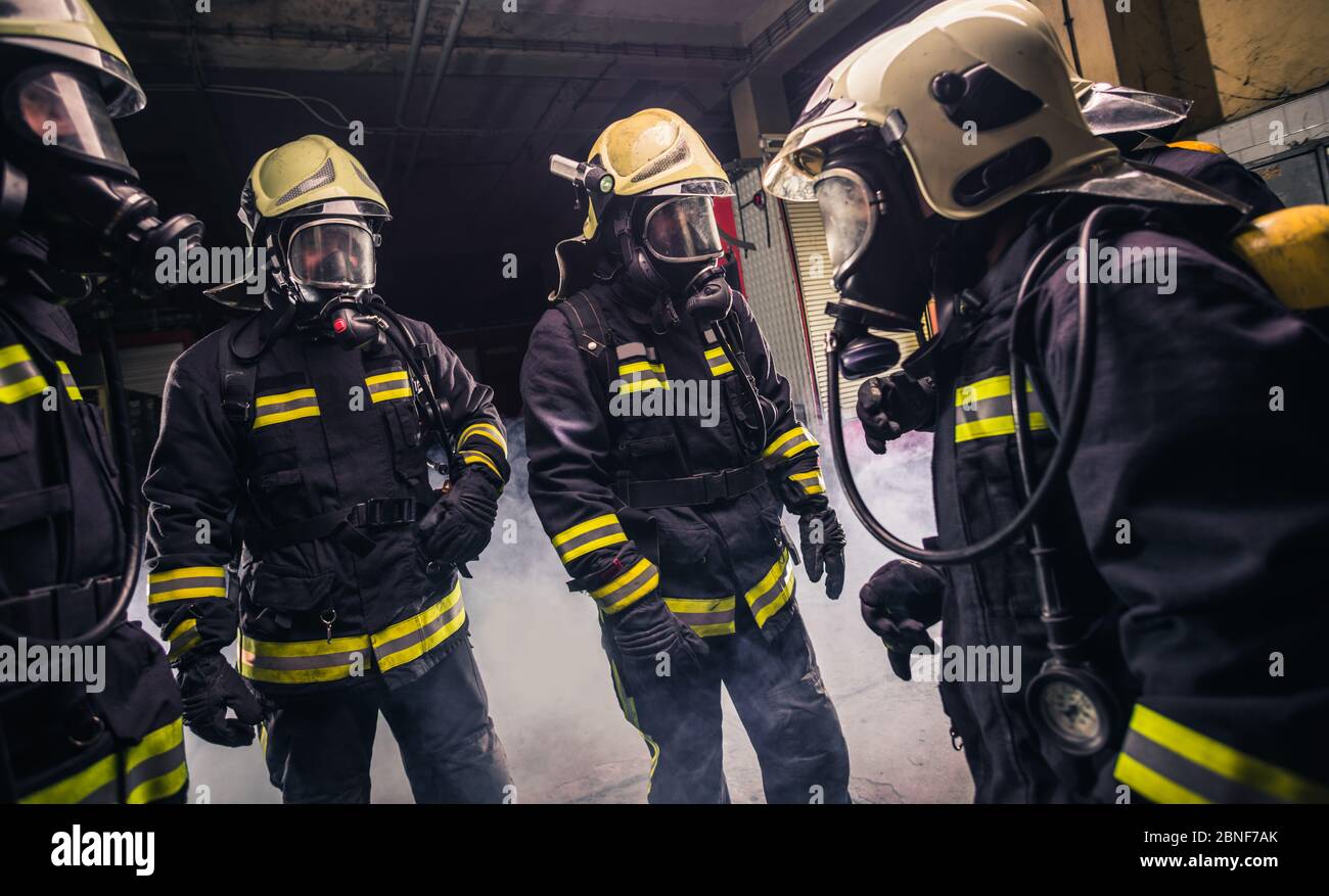 Group of firefighters in the fire department checking their gas mask ...
