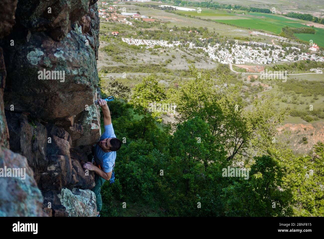 Muscular rock climber practicing rock-climbing on a rock wall Stock ...