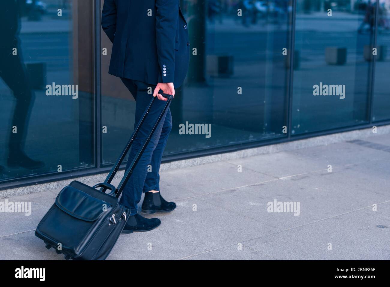 Close up photo a formal businessman dragging his suitcase, manbag, pull ...