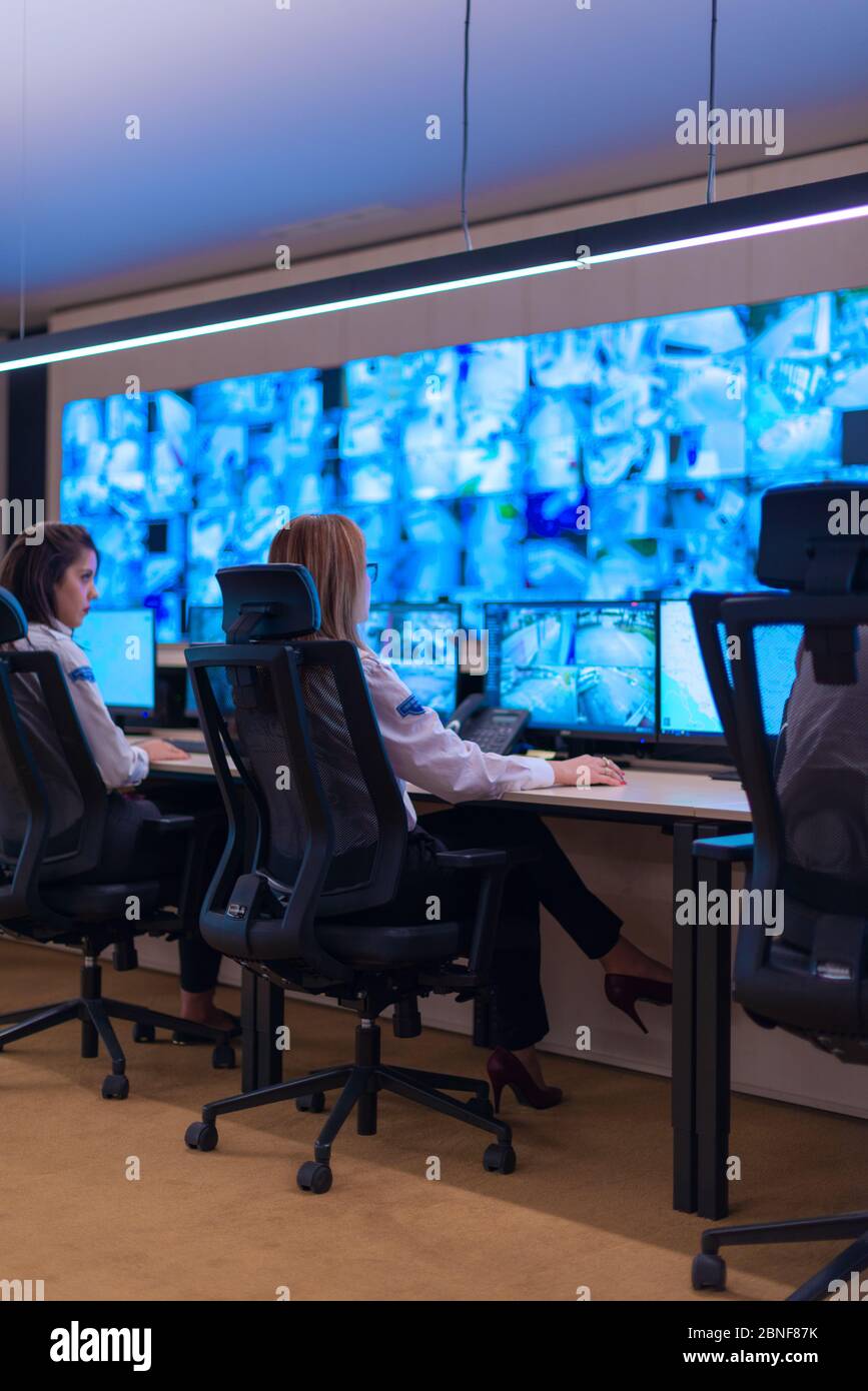 Female security guards working on computers while sitting in the main ...